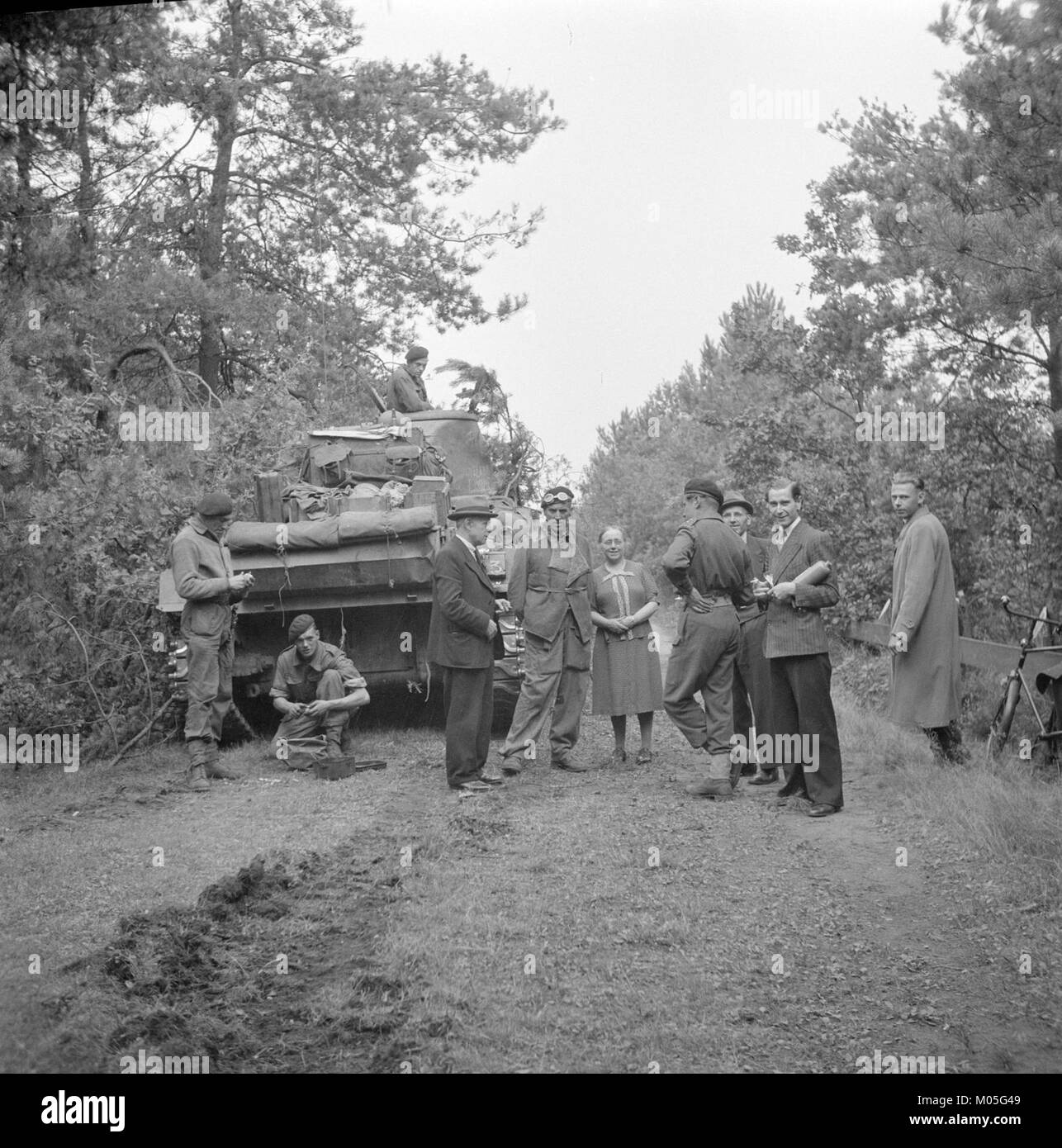 The image shows civilians conversing with military personnel in a ...