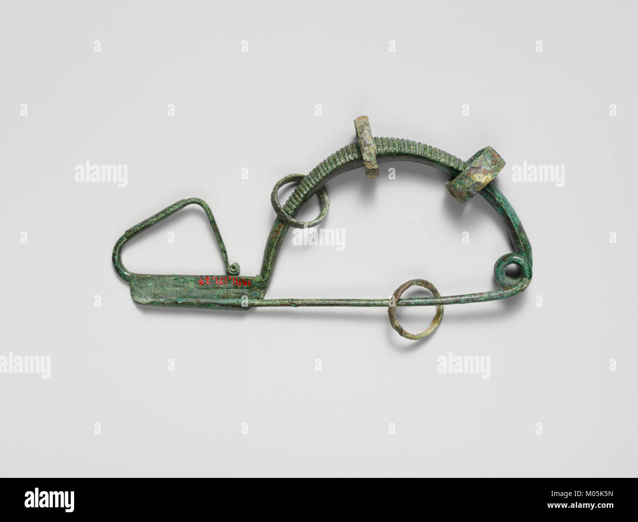 The bronze fibula, an ancient safety pin with four rings, is a ...