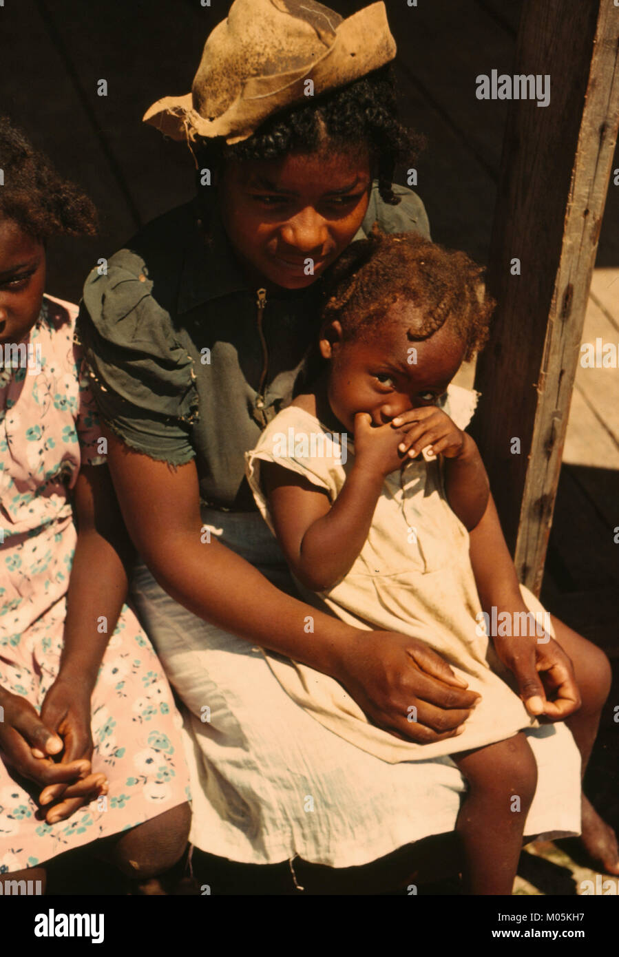 Three Negro children sitting on the porch of a house Stock Photo - Alamy