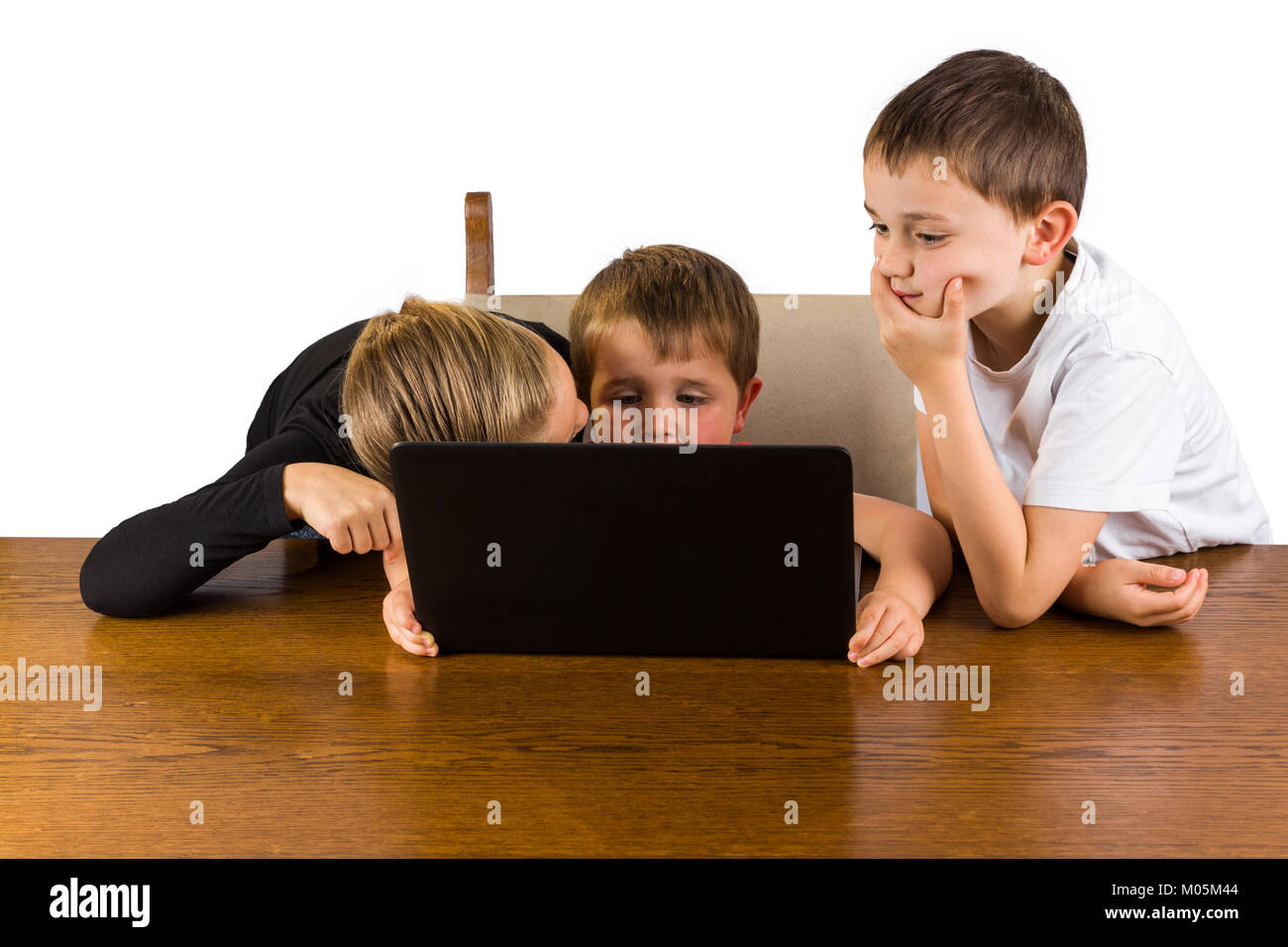 cute little boy looking on a laptop while getting help from his older ...