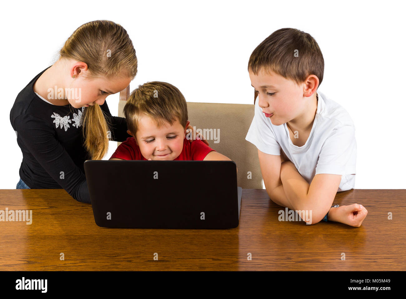 cute little boy playing on a laptop getting help from his older sister ...