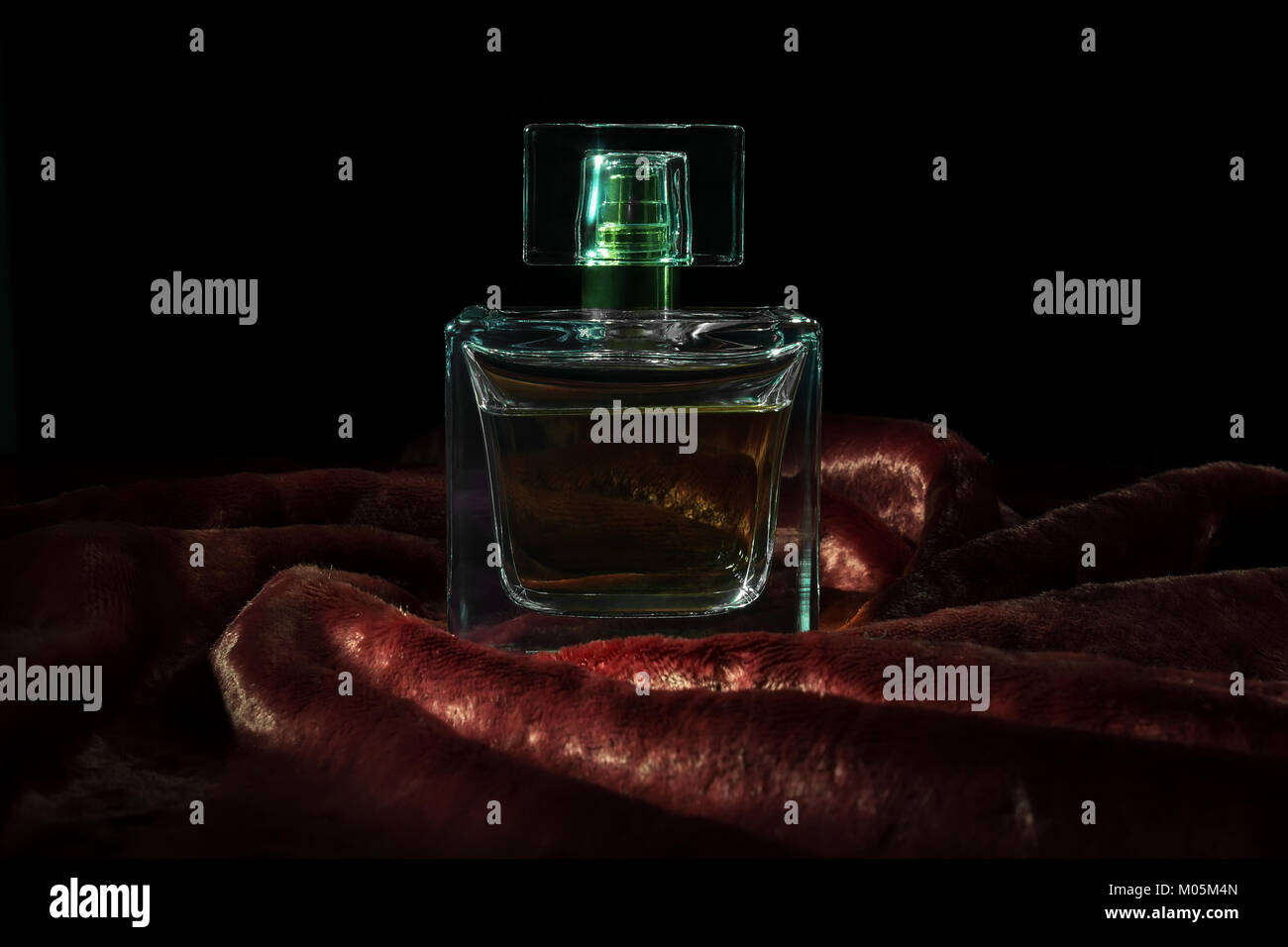 a bottle of perfume on a red velvet and a black background Stock Photo ...