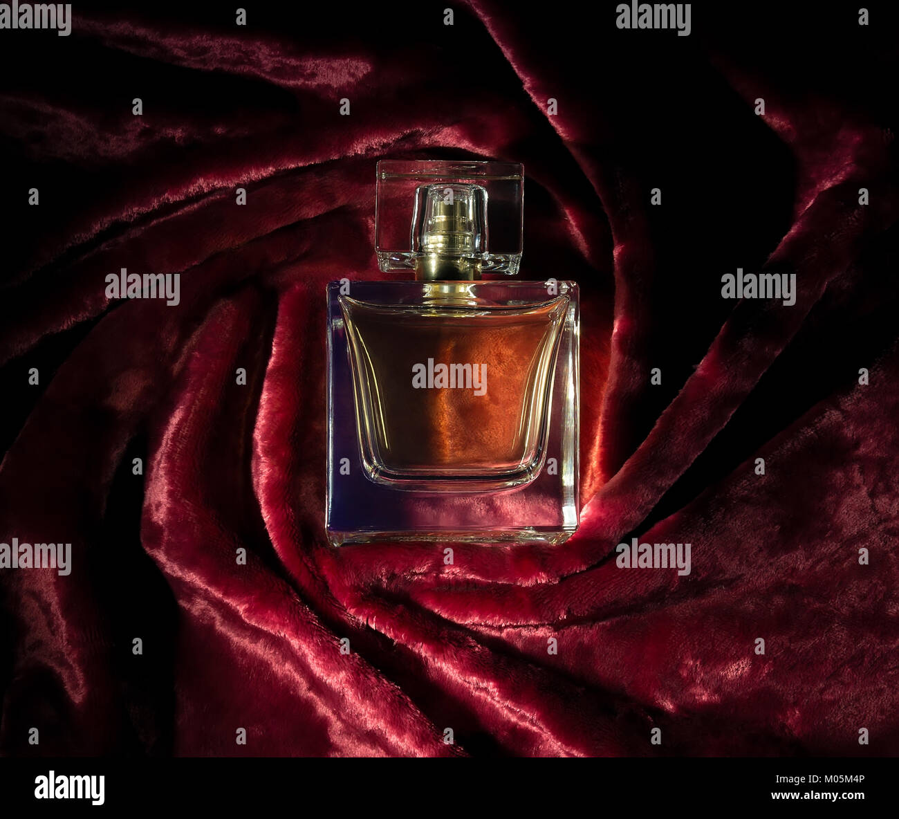 a bottle of perfume on a red velvet and a black background Stock Photo ...