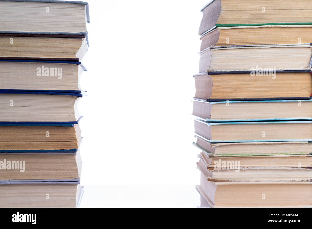 two piles of old books next to each other on a white background Stock ...