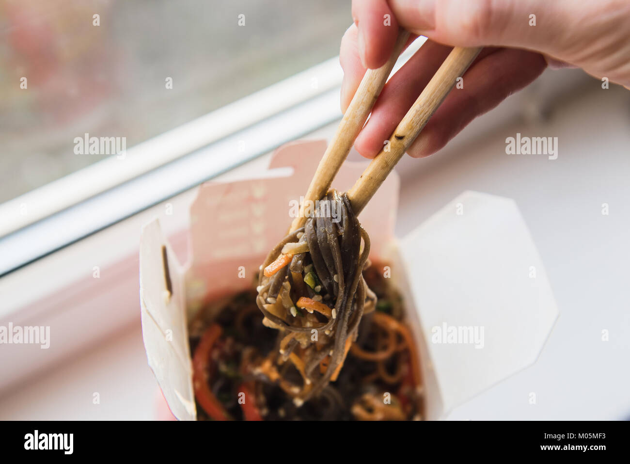 Hands with chopsticks taking food Stock Photo - Alamy