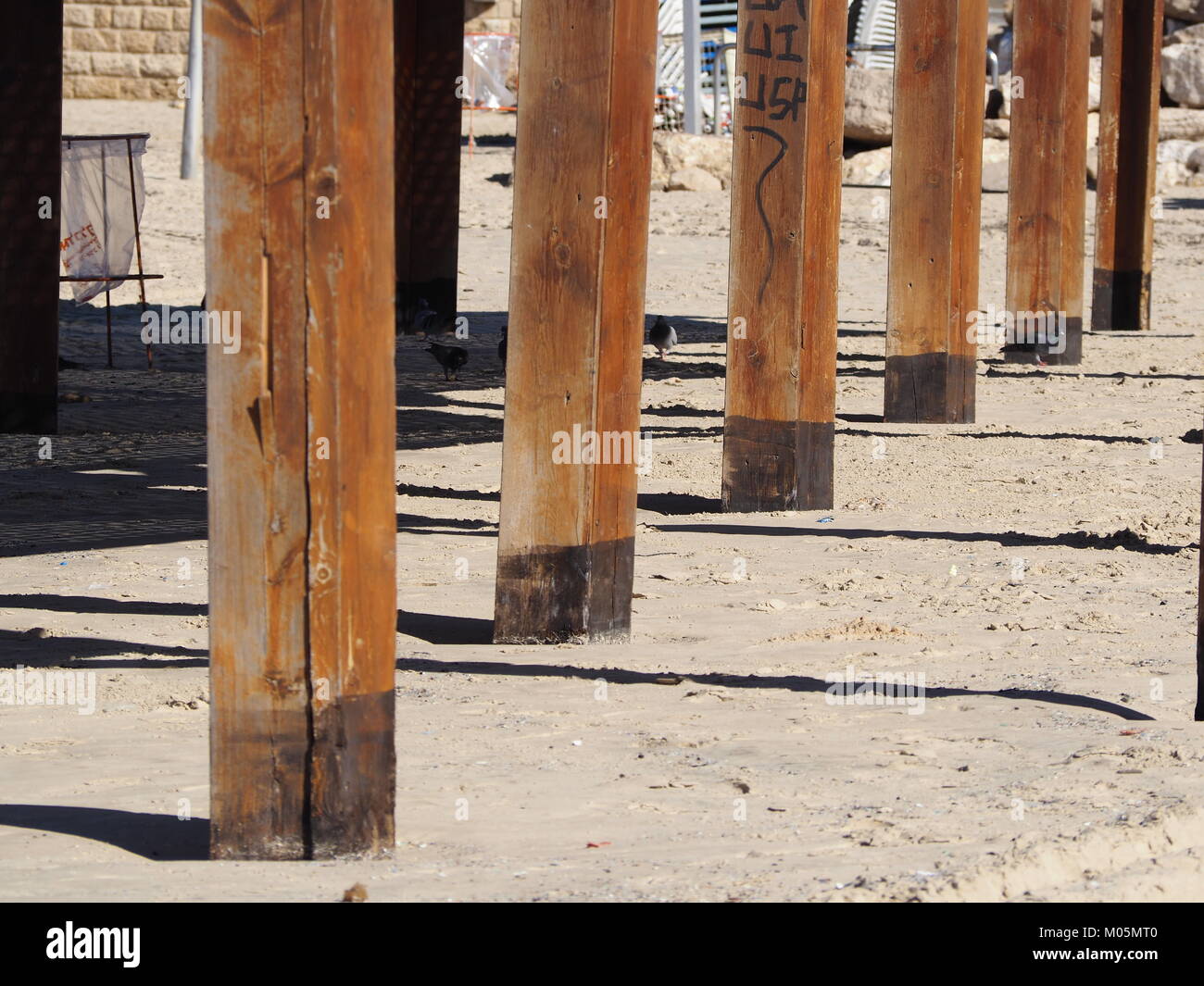 Shades of wooden sun shade pillars on sandy beach Stock Photo - Alamy