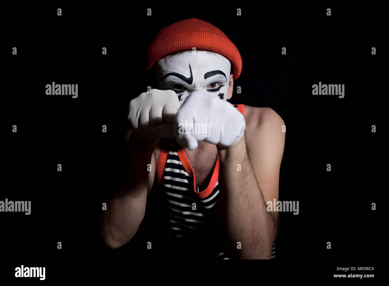 Portrait of fighting mime on a black background Stock Photo - Alamy
