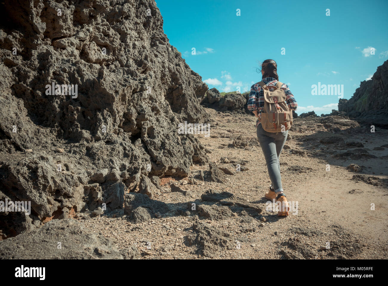 back view photo of young attractive female hiker climbing trail in ...