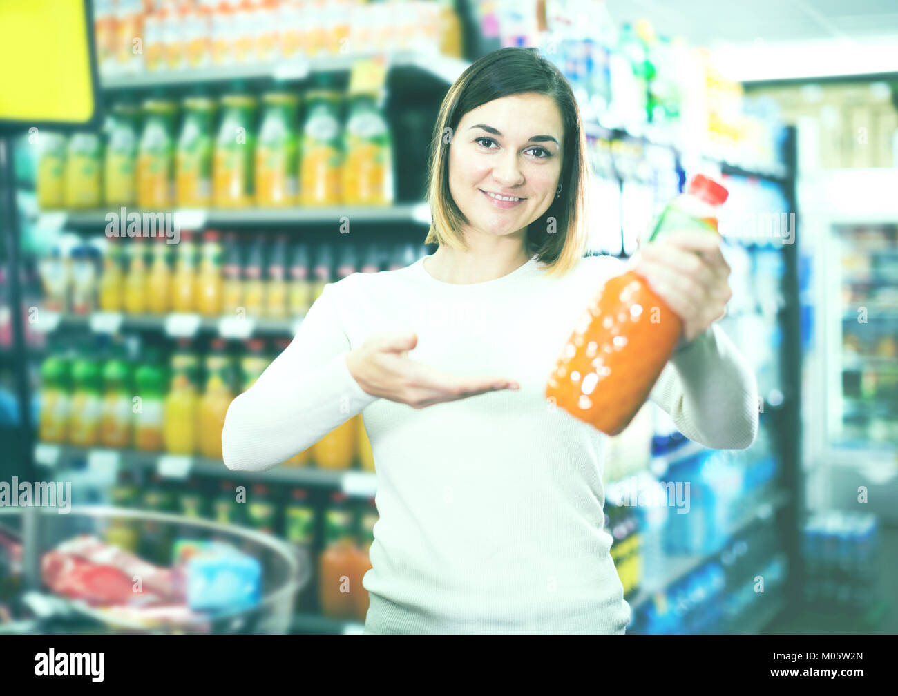 Beautiful young woman searching for beverages in supermarket Stock ...