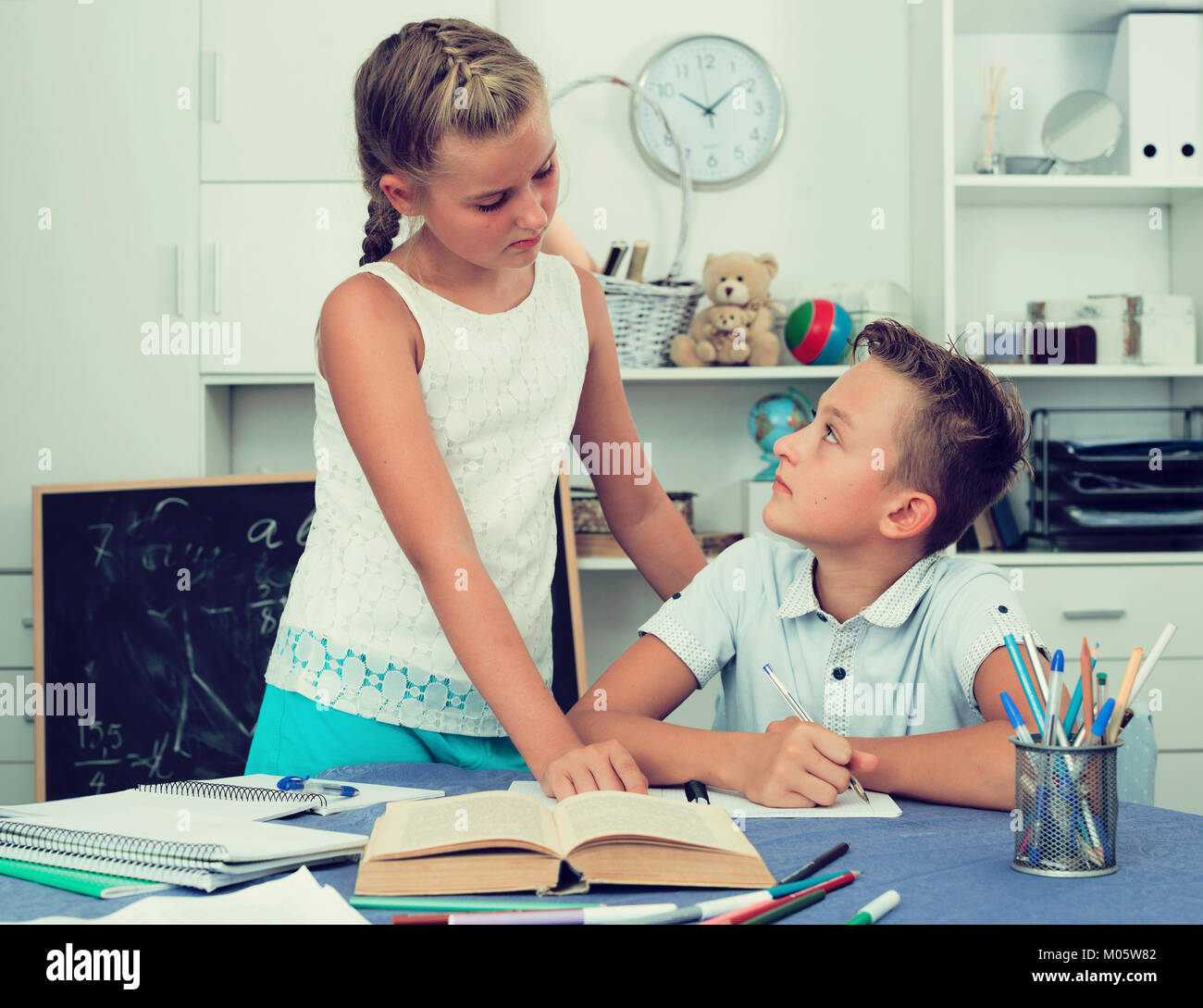 Sister is helping brother with homework at home Stock Photo - Alamy