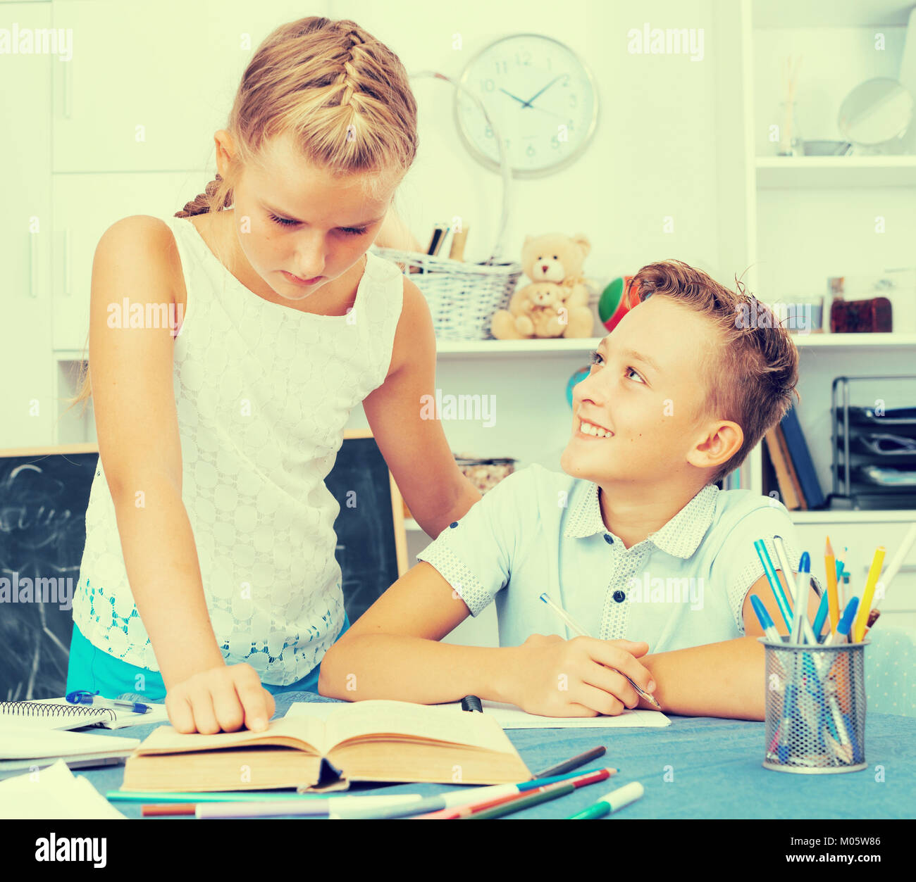 Girl is helping brother doing homework at home Stock Photo - Alamy