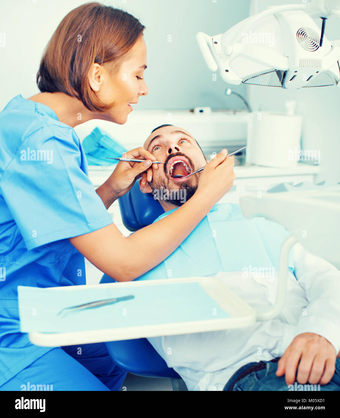 Pleasant cheerful stomatologist girl in uniform is taking visional ...