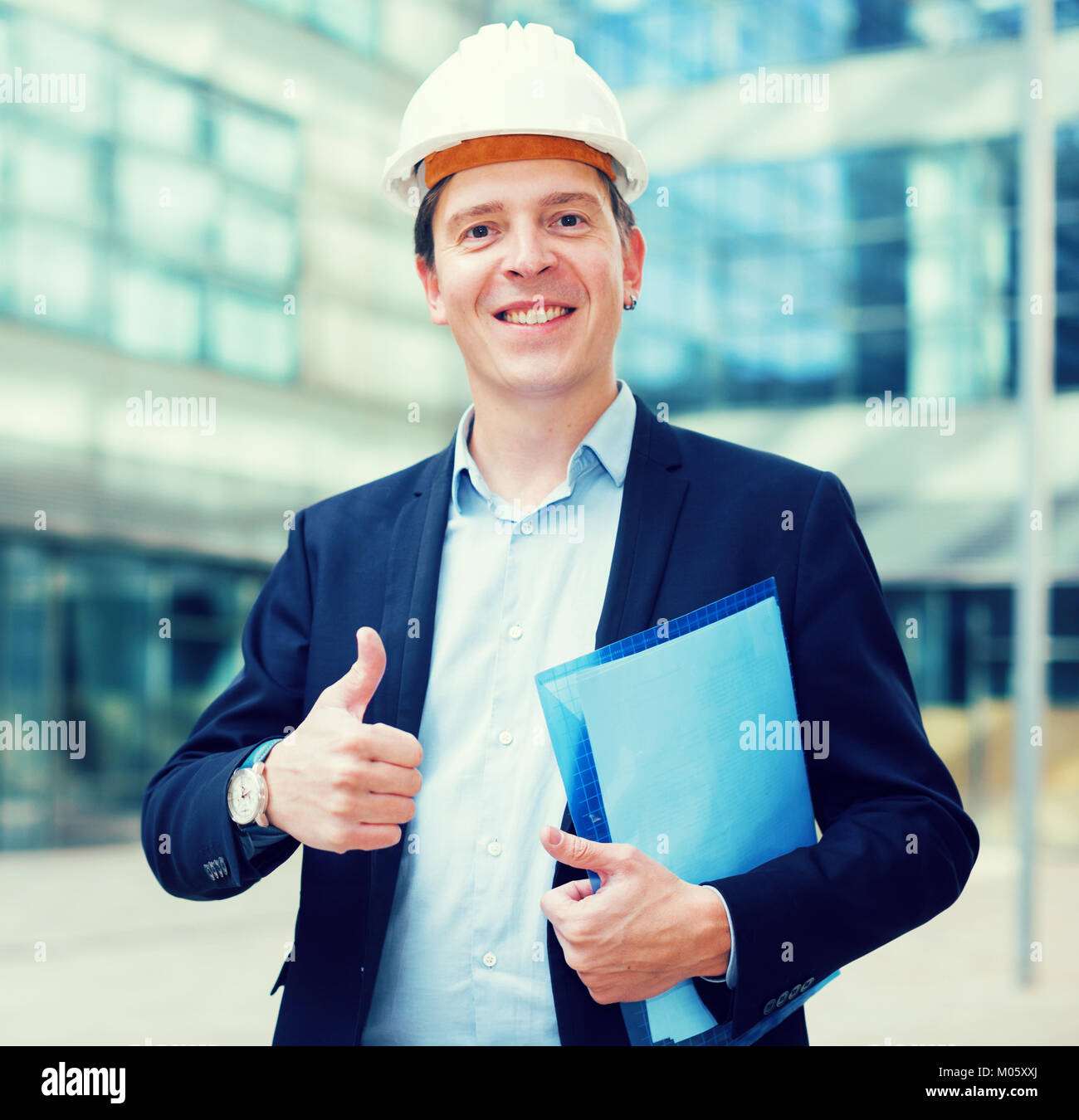 Professional man in jacket and helmet working with documents Stock ...