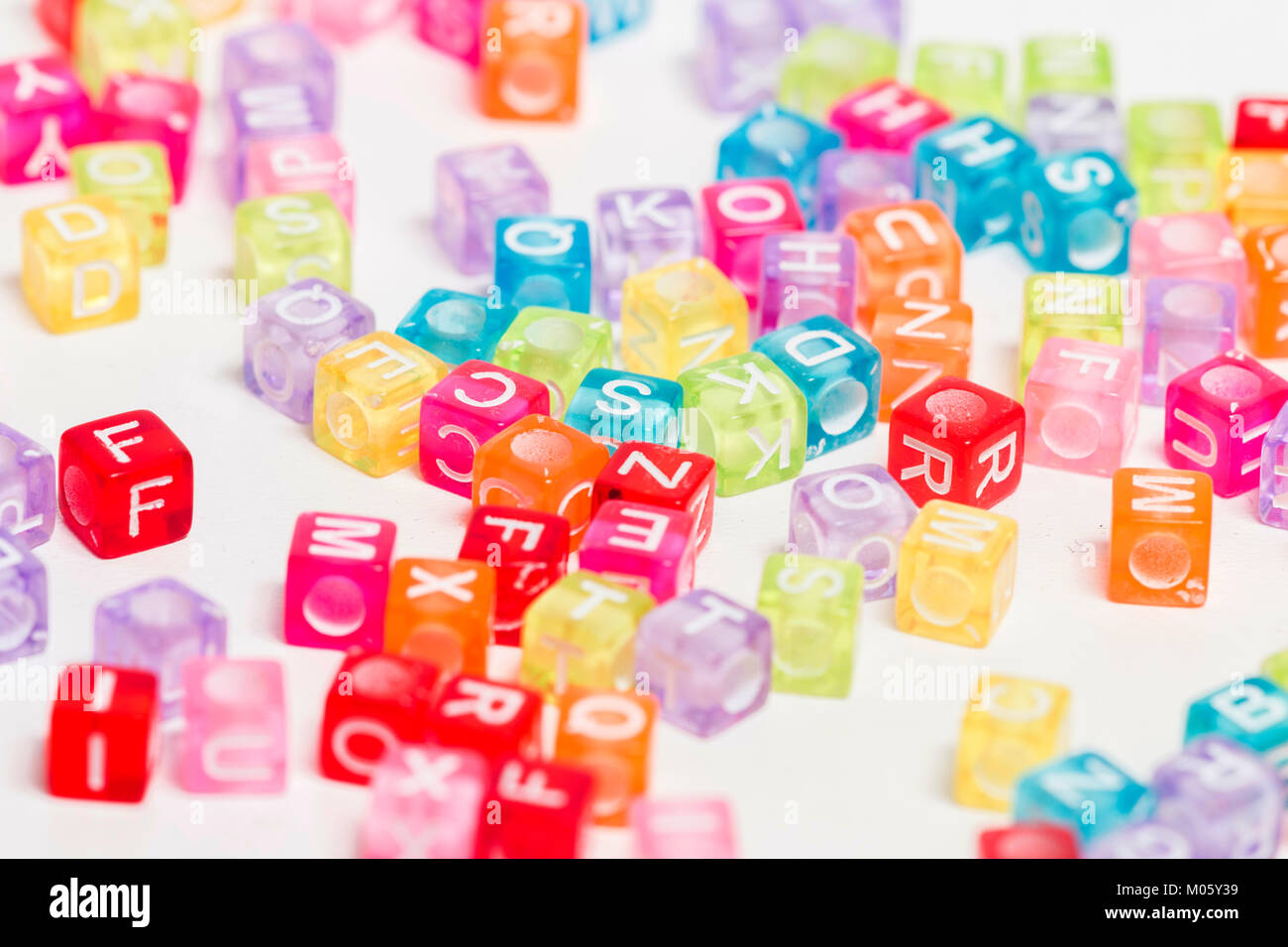 Colorful plastic beads with letters isolated on a white background ...