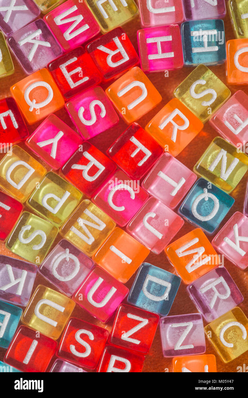 Colorful plastic beads with letters isolated on a white background ...