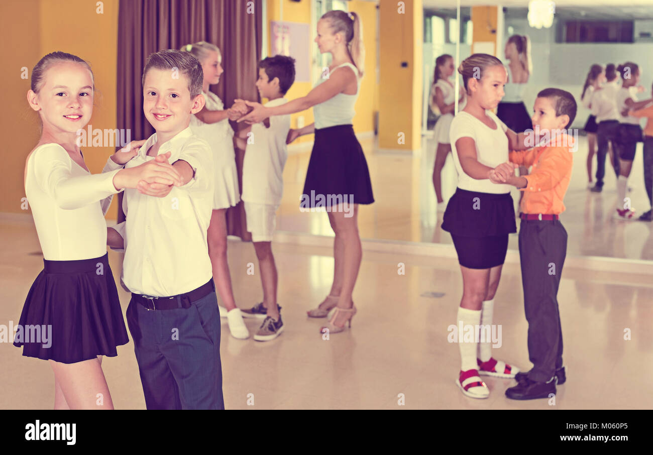 Group of friendly smiling children dancing tango in dance studio Stock ...