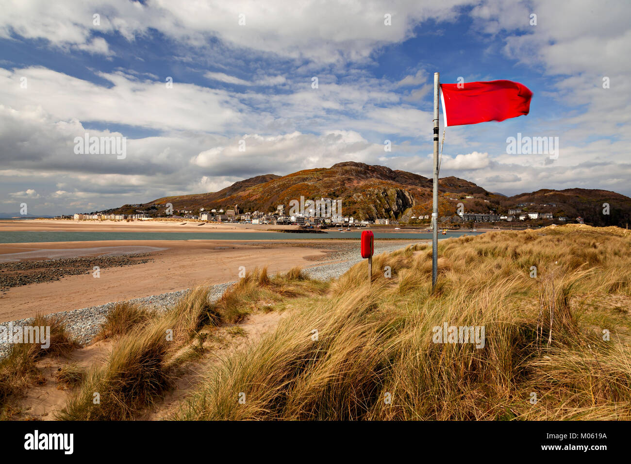 Sand dunes and red warning flag at Fairbourne on the wels coast, with ...