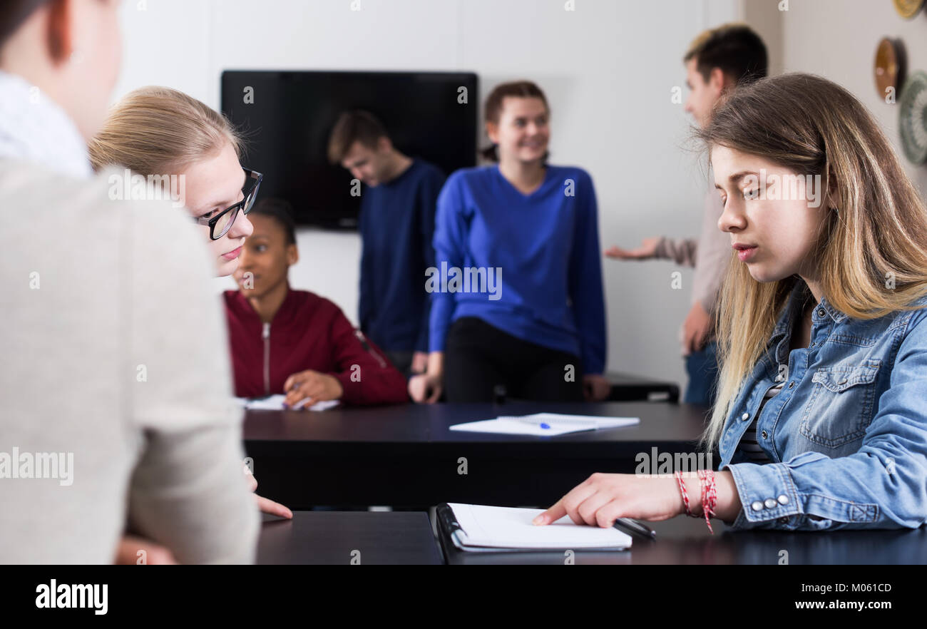 Girl consulting fellow student during test examination in class Stock ...