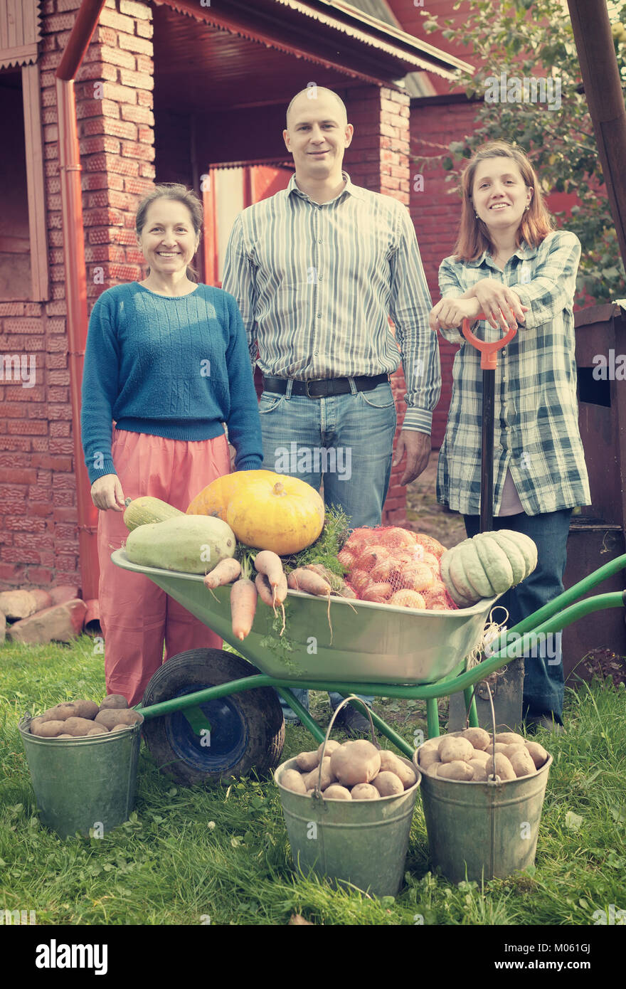 Happy family with vegetables harvest in garden Stock Photo - Alamy