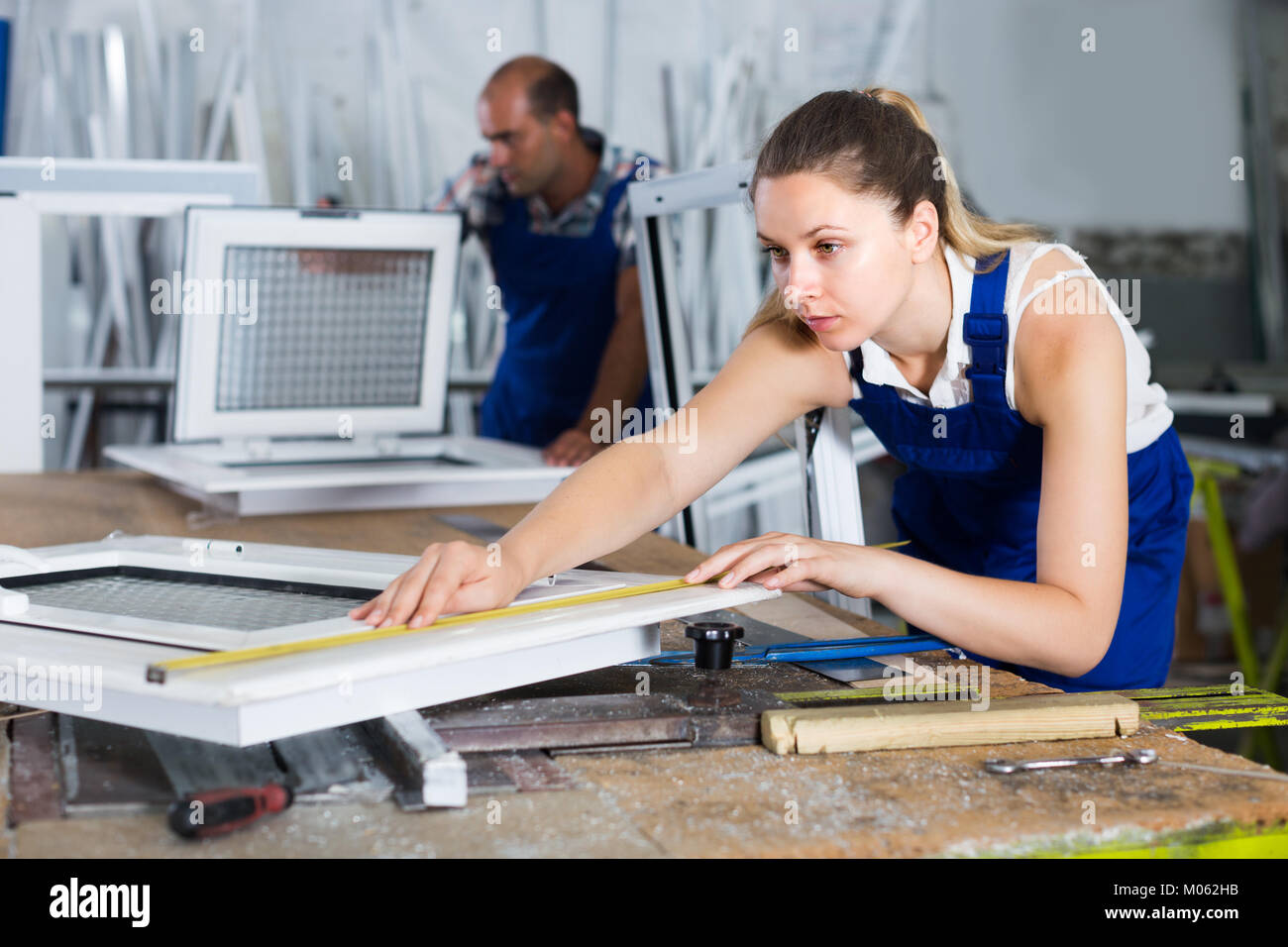 Woman is checking dimensions of finished plastic window using measuring ...