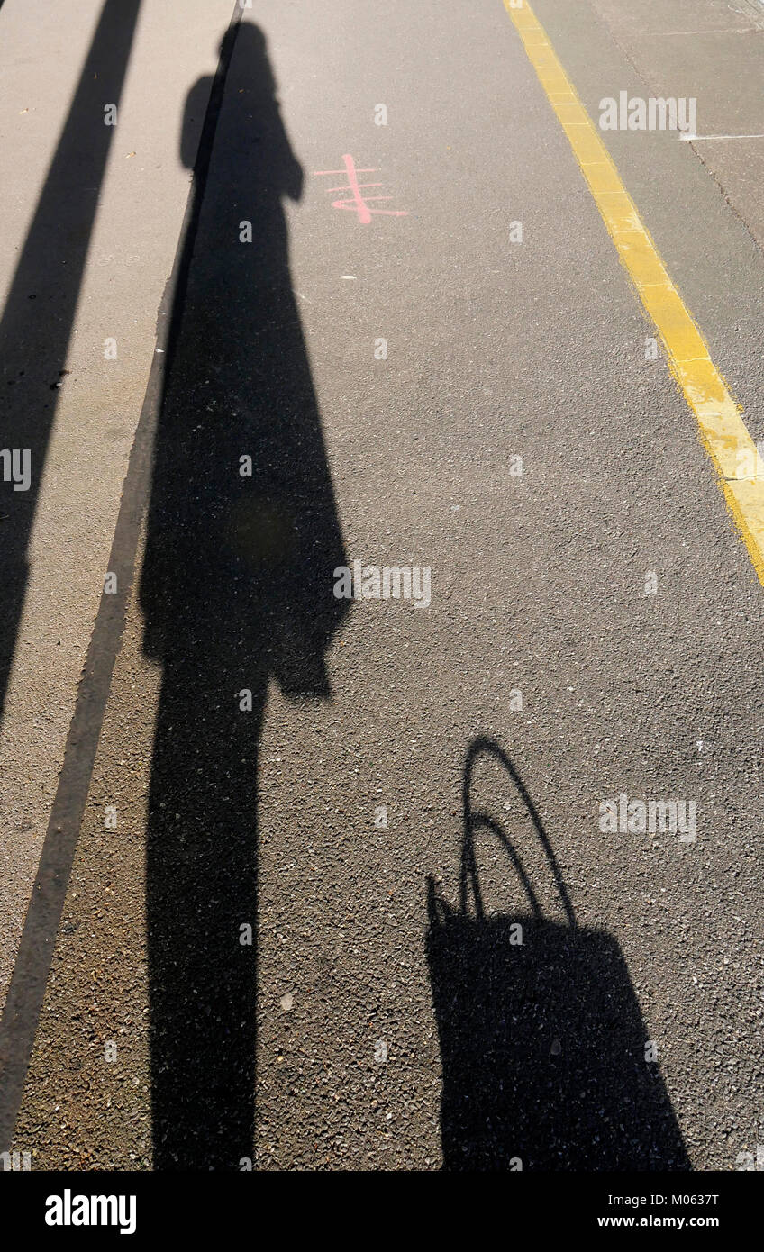 Shadow of photographer and handbag on railway station platform ...