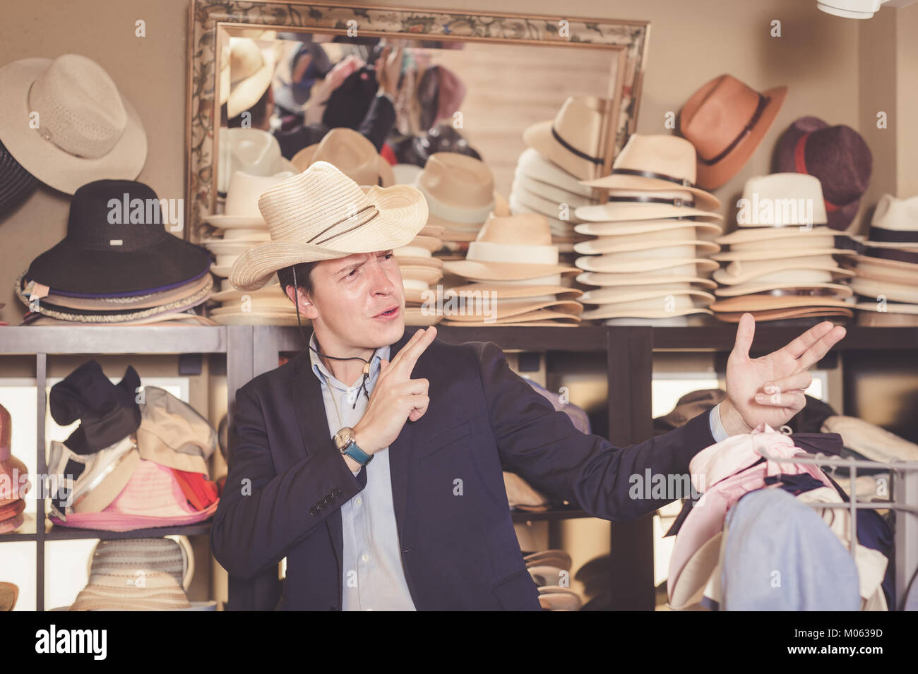 happy male try on cowboy hat from the range at the shopping center ...