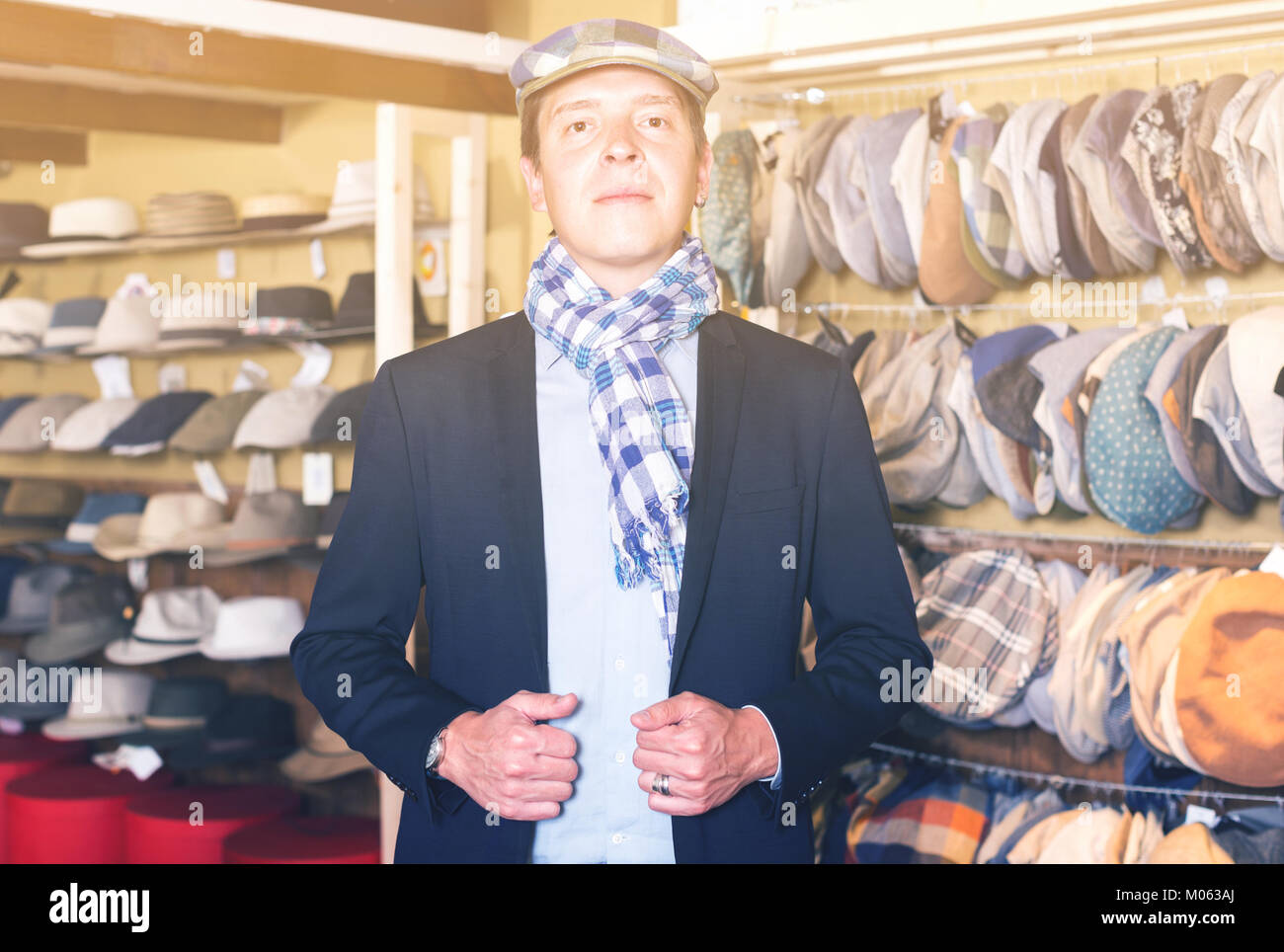 portret of positive american young male try on newboy cap at the ...
