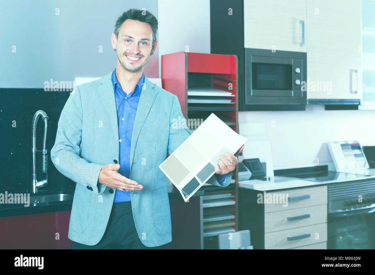 Smiling salesman of furniture accessories store demonstrating variants ...