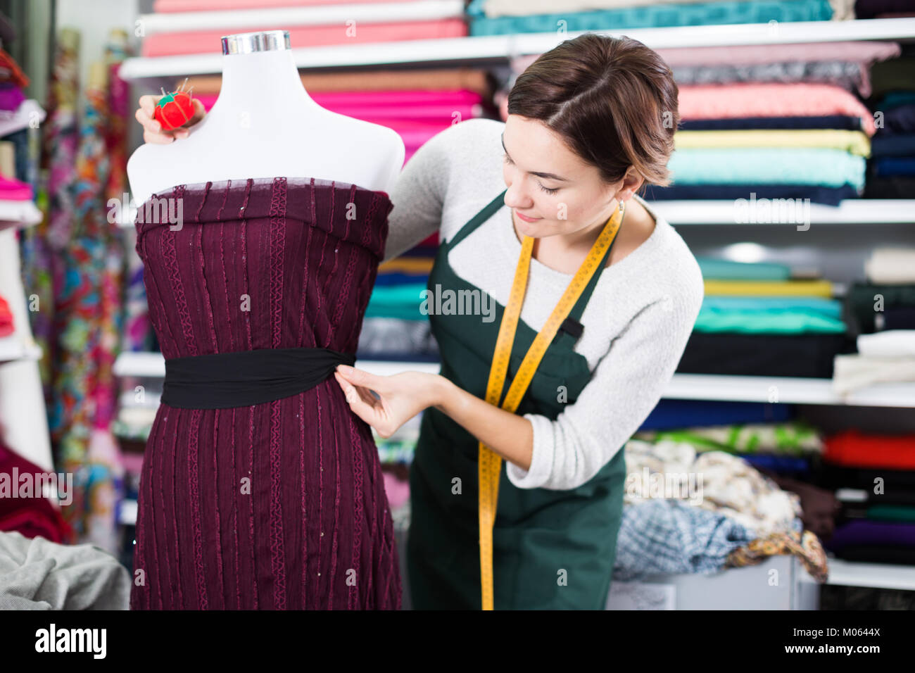 Young woman tailor taking measurements from dress at studio Stock Photo ...