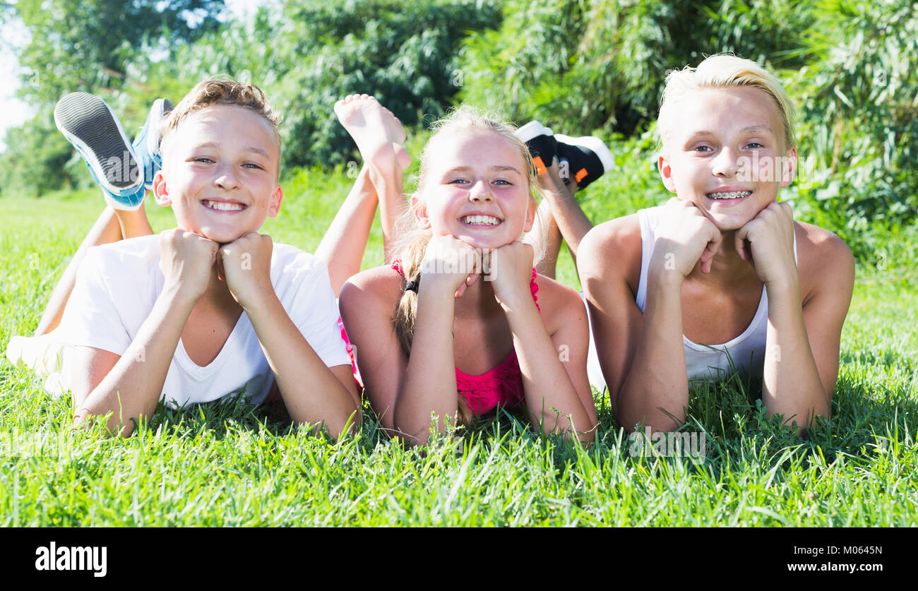 Laughing children playing outdoors funning at grass on summer day Stock ...