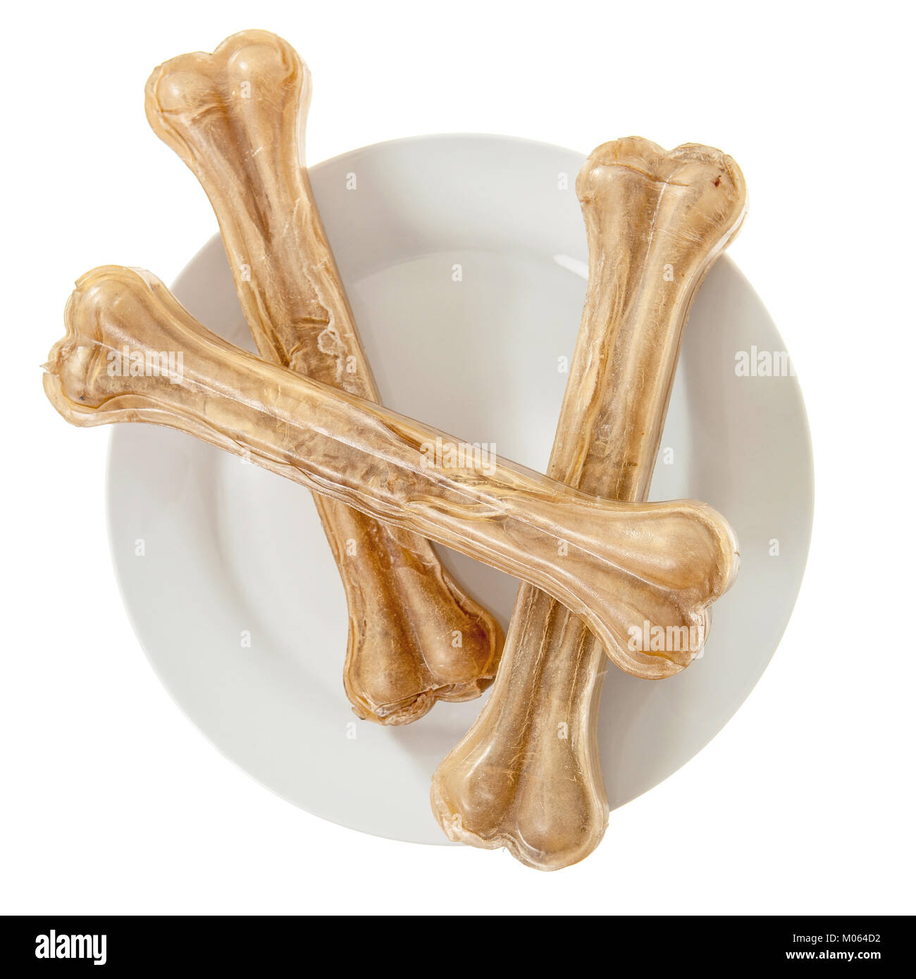 Three dog bones on plate isolated over white Stock Photo - Alamy