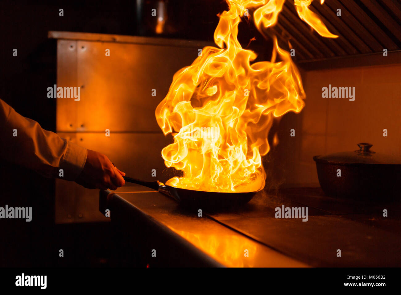Flambe lamb rib roast. Cooking with fire in frying pan. Professional ...