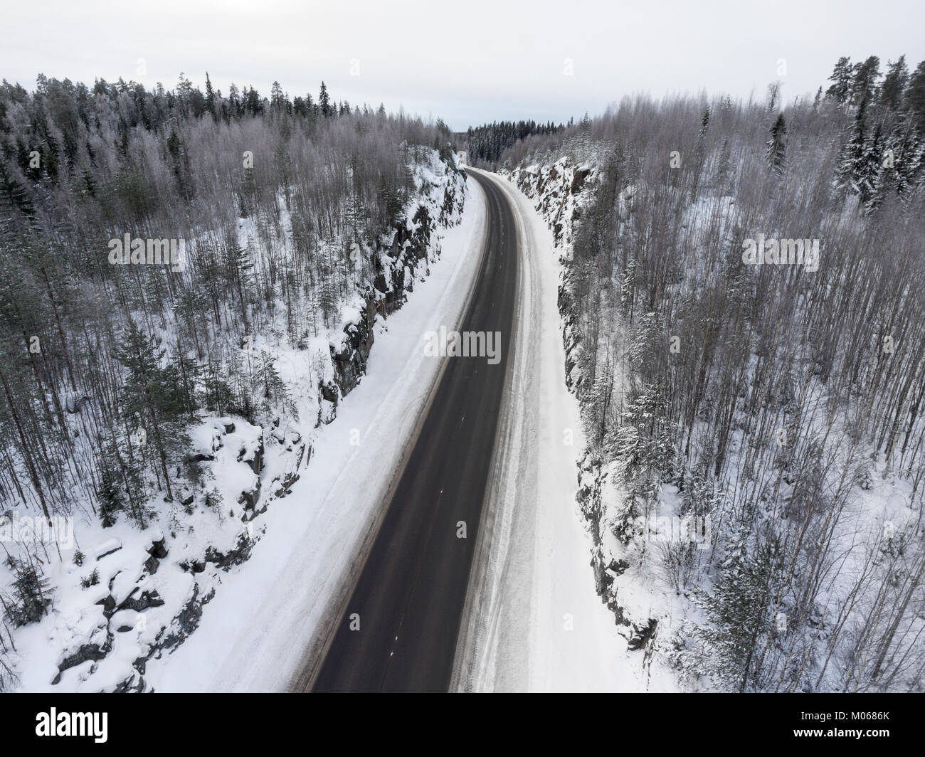 Winter highway through the mountains and evergreen forest in north of ...