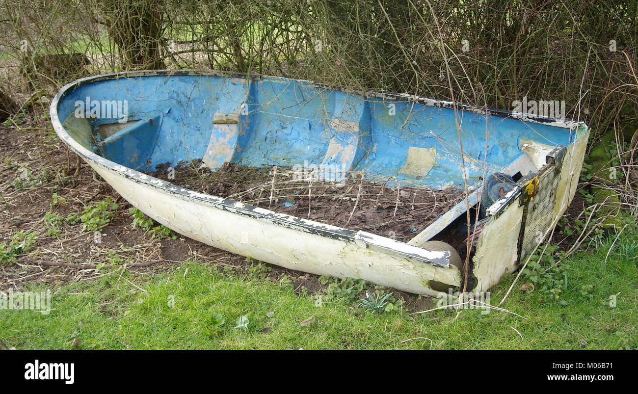 The broken rowboat shows damage and weathering, illustrating the ...