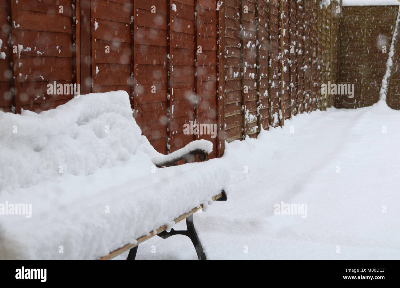 Build up of snow in a back garden with bench and fence Stock Photo - Alamy