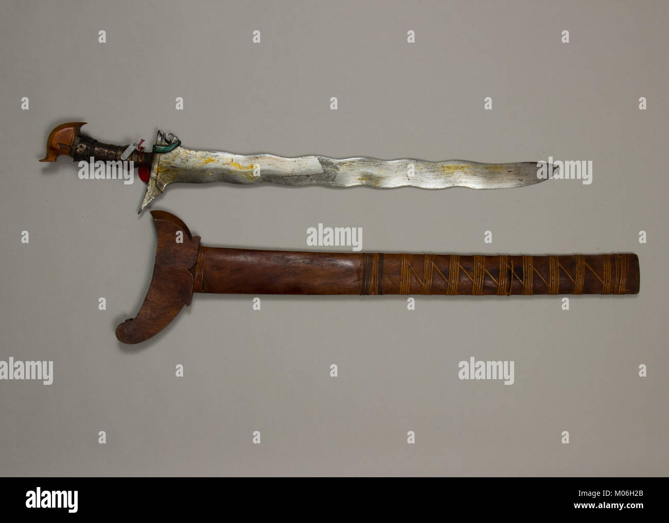 A Kris dagger with its sheath, characterized by its wavy blade and ...