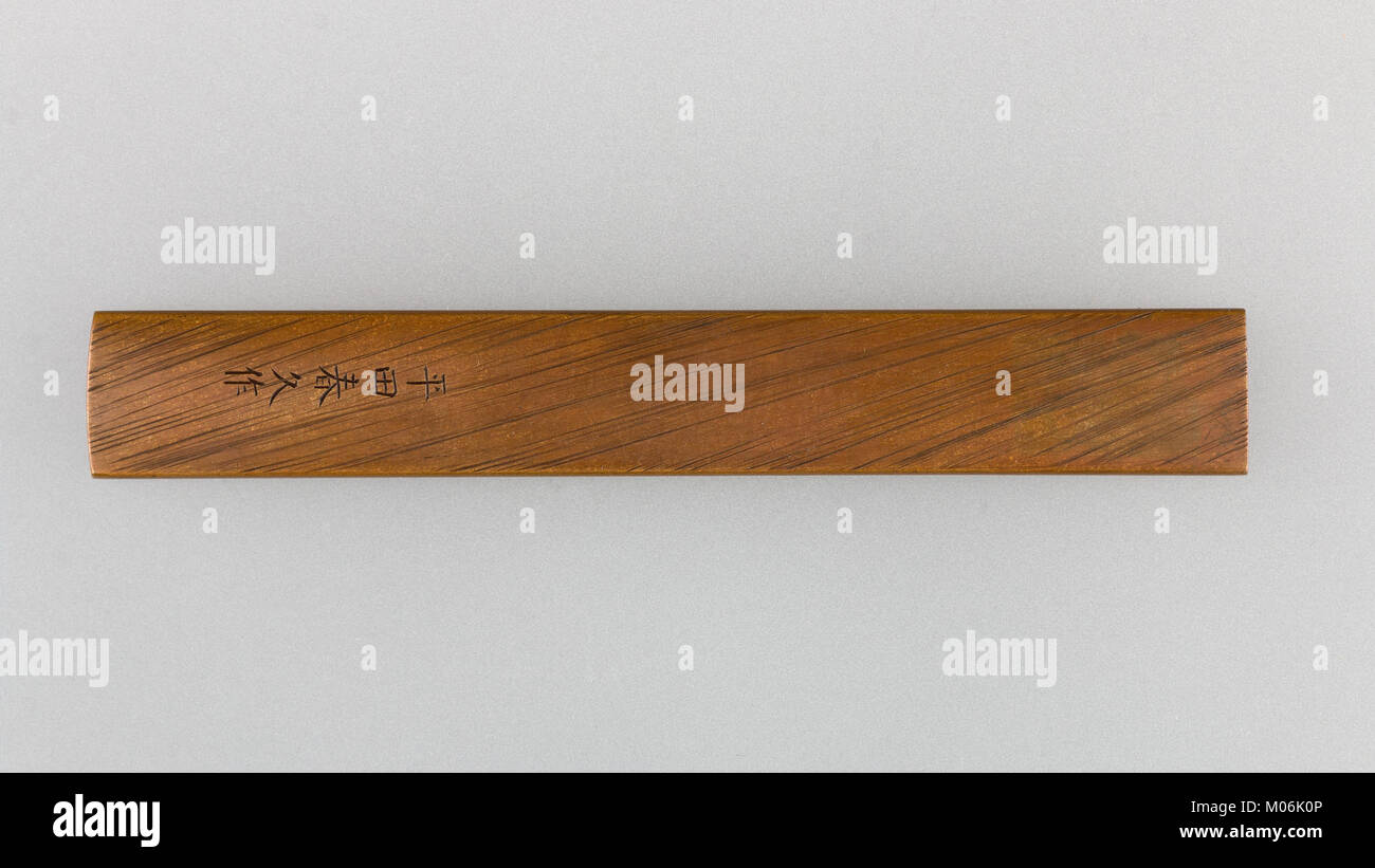 A Japanese knife handle (Kozuka), intricately designed, likely from the ...