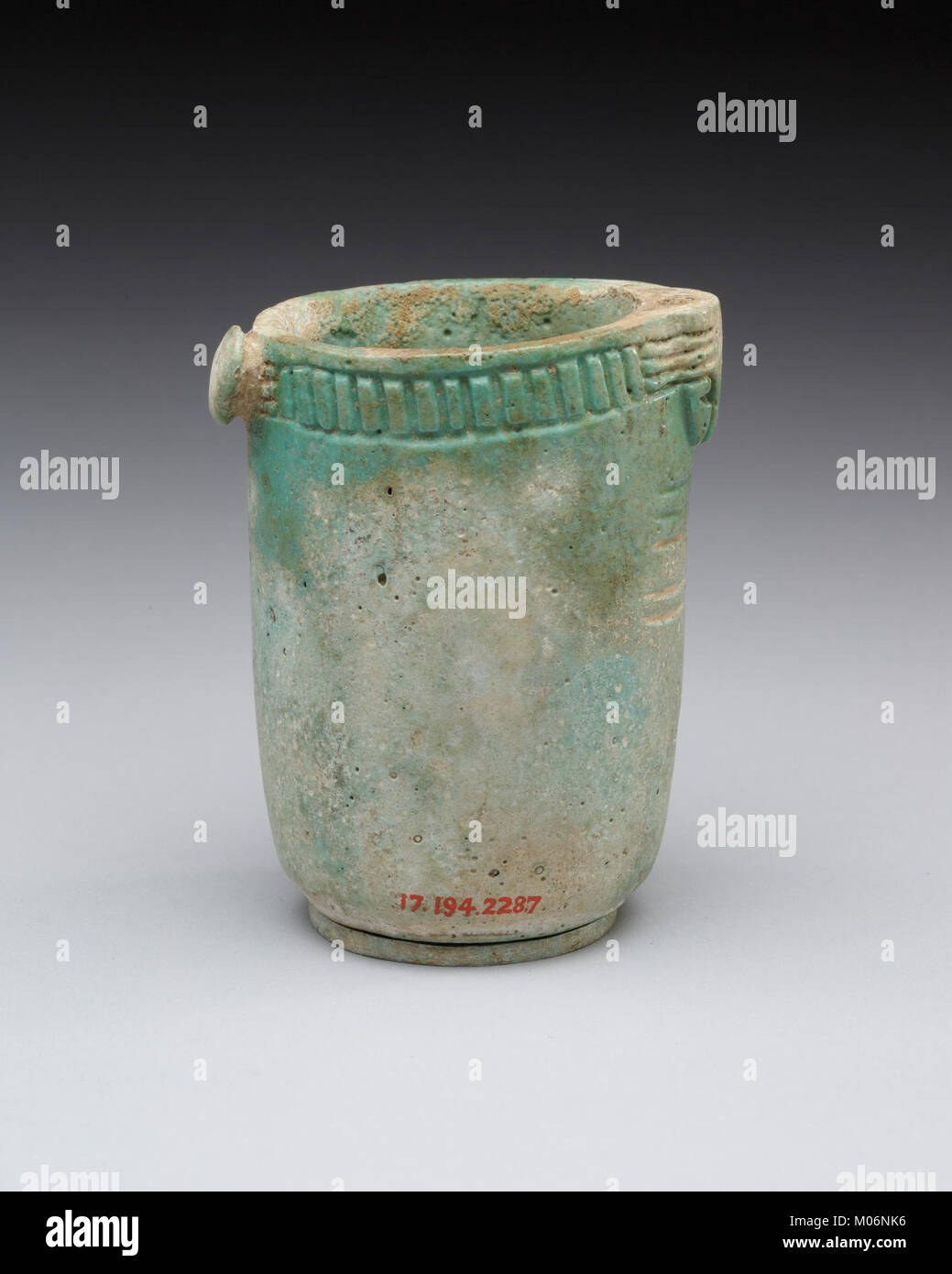A jar with a decorated rim, swivel, and knob, showcasing ancient ...