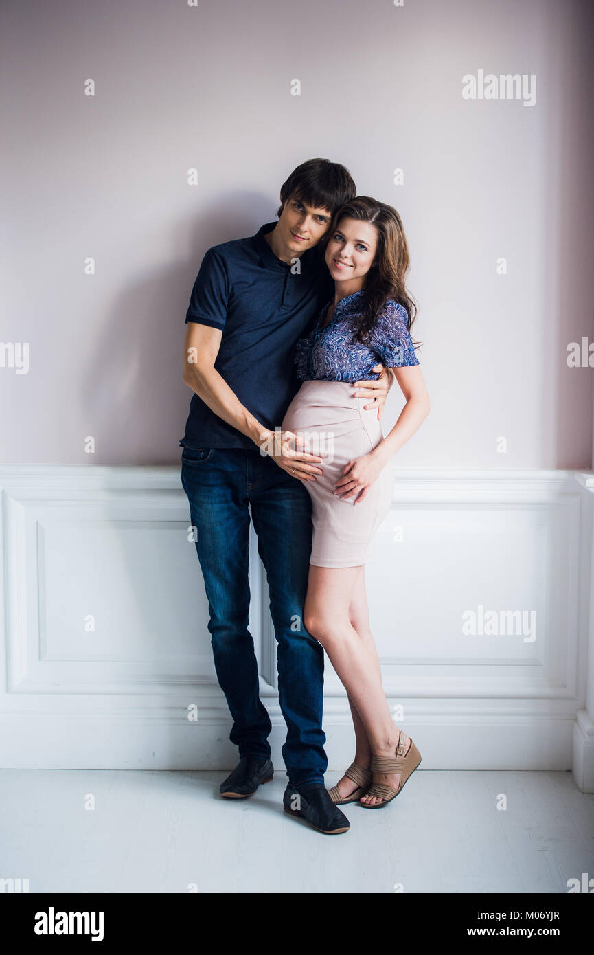 Man kissing his pregnant wife and touching her belly Stock Photo - Alamy