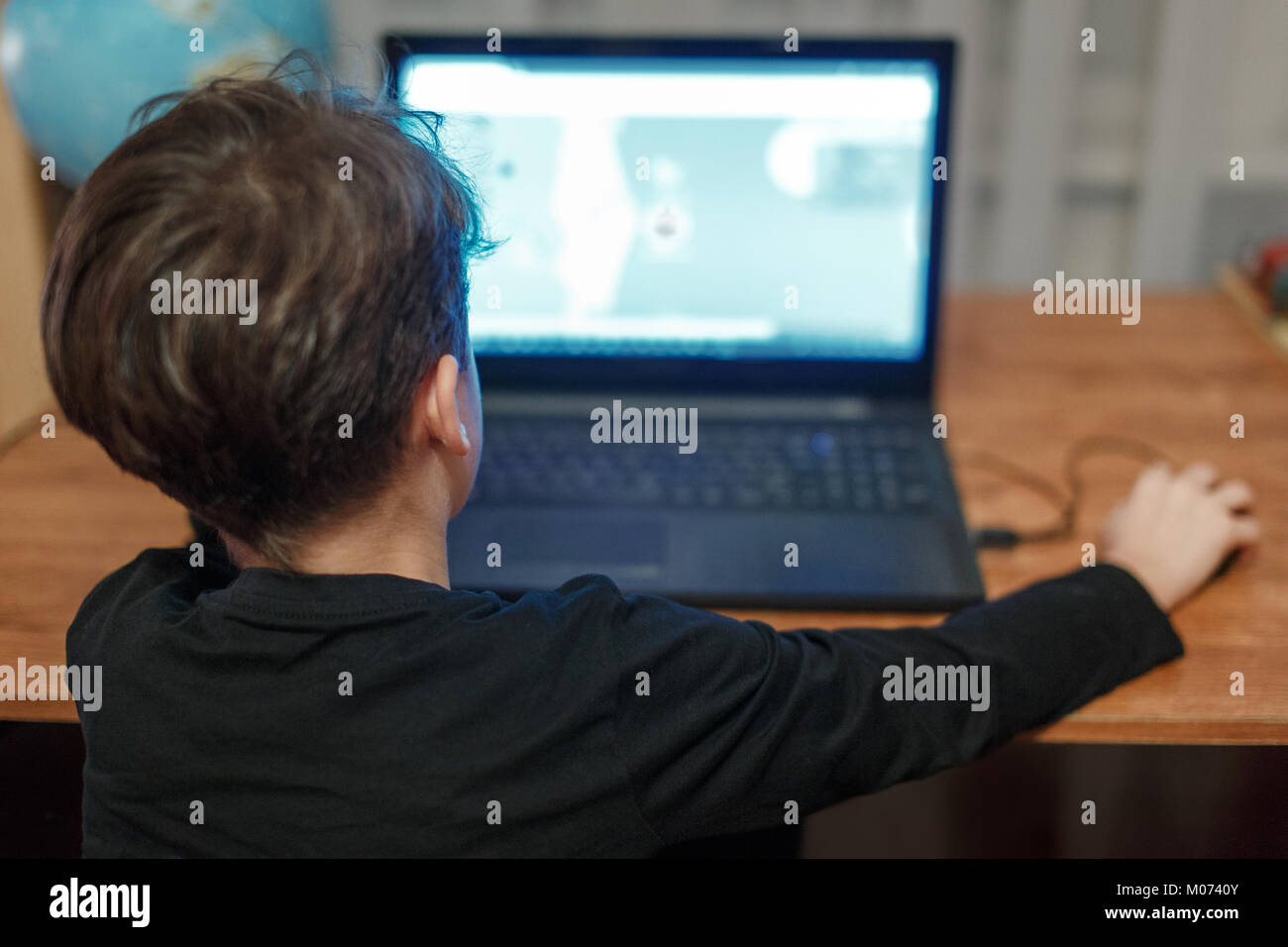 Little kid playing on laptop at home video game Stock Photo - Alamy