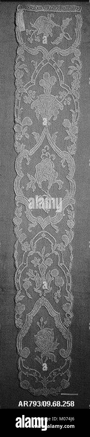 This lappet is a decorative garment accessory with intricate designs ...