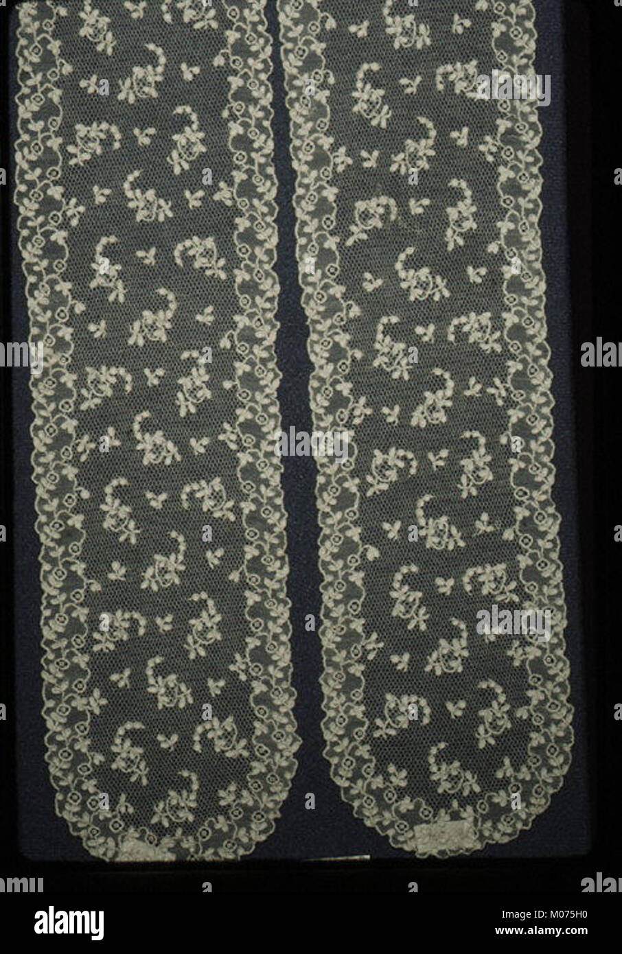 This lappet is a decorative textile accessory worn on garments ...