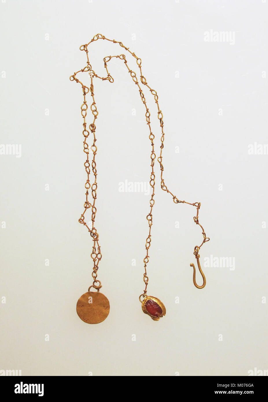 A necklace featuring a disc and sard, showcasing intricate design work ...