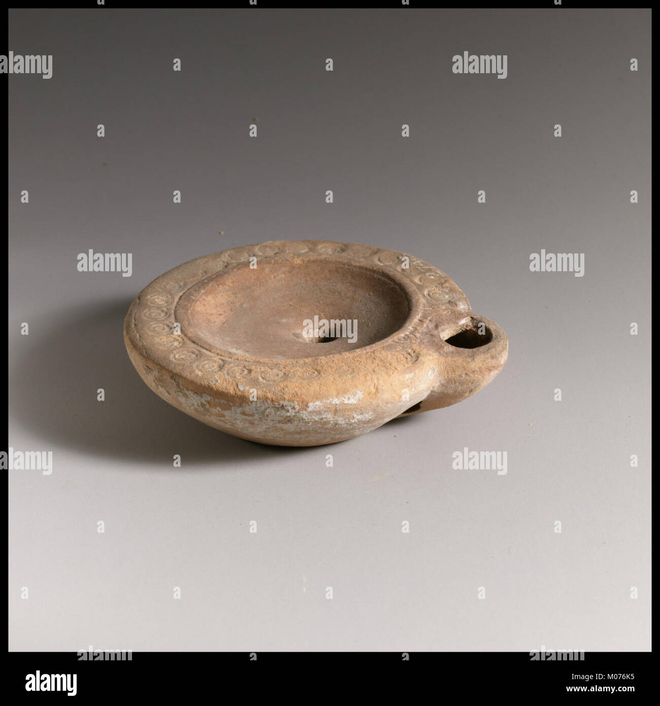 This ancient lamp, cataloged MET DP803, demonstrates early lighting ...