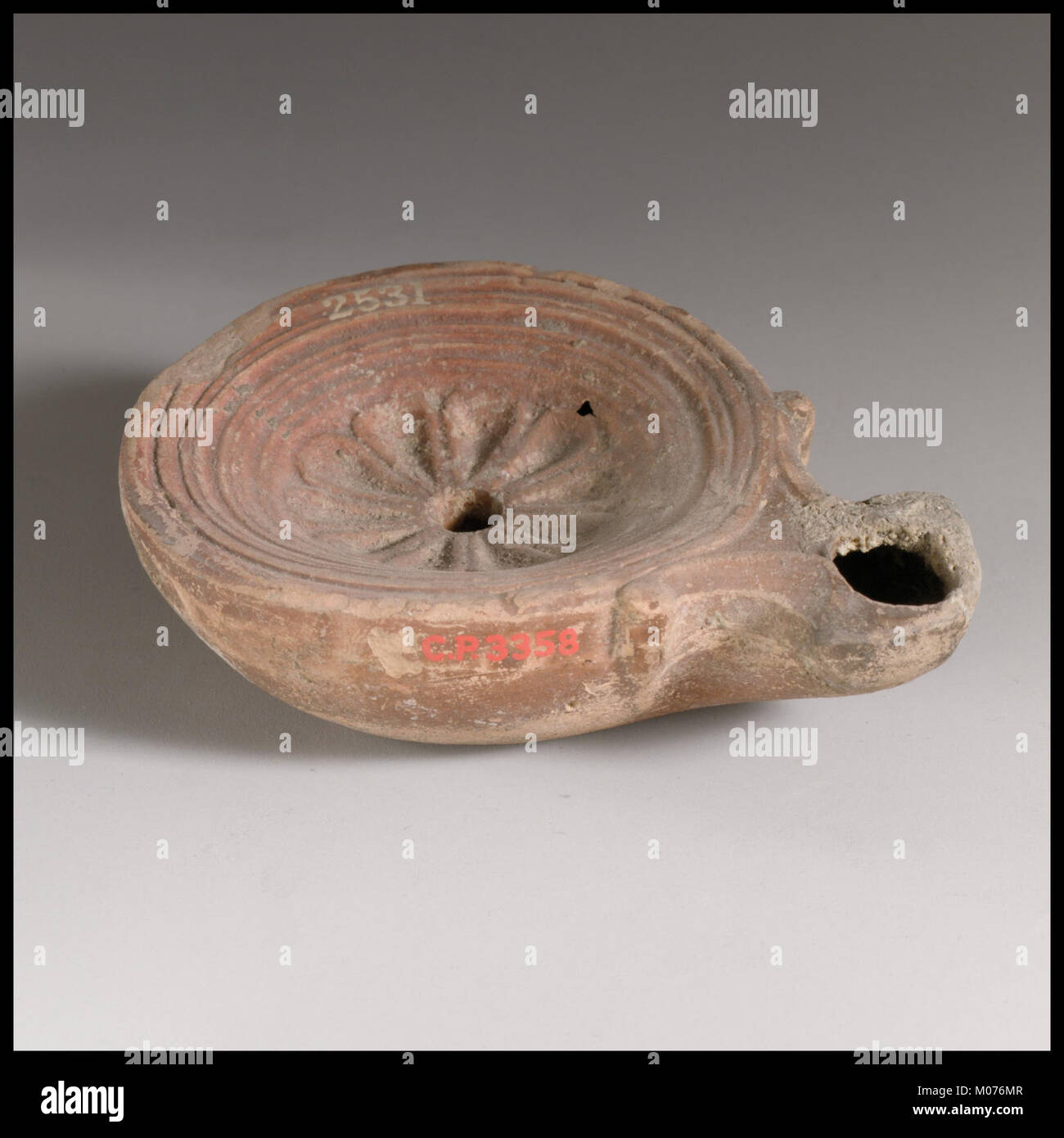 This lamp, likely used in ancient times, features a functional and ...