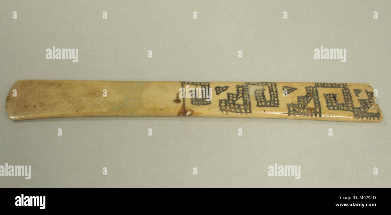 A prehistoric bone spatula with incised markings, likely used for ...