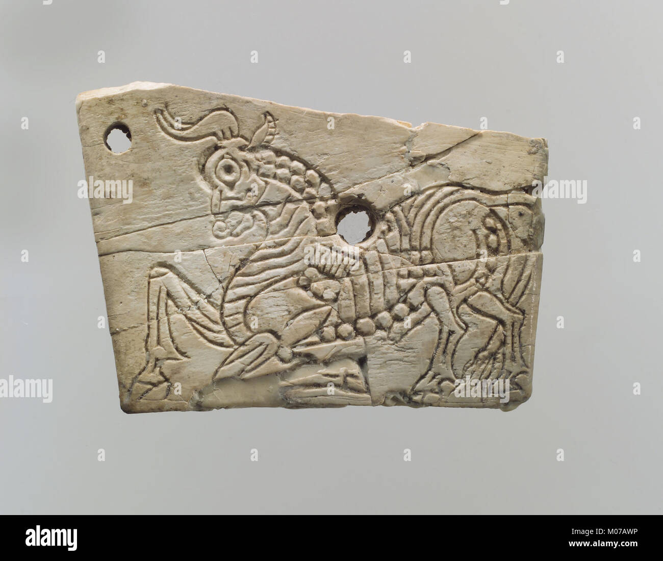This incised plaque depicts a kneeling bull, carved into the surface of ...
