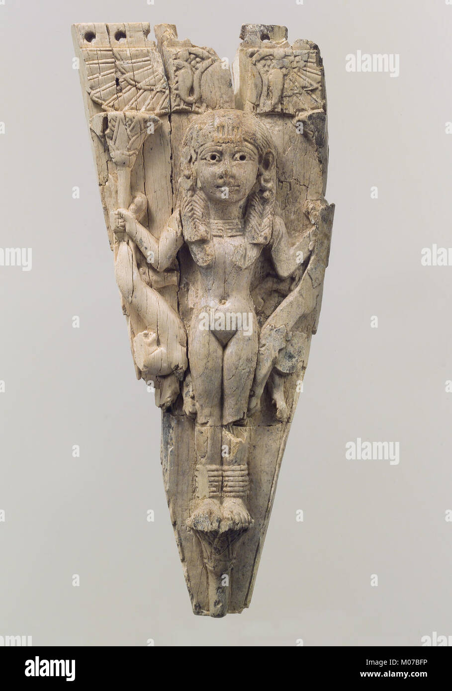 This horse frontlet features a female figure carved in relief, flanked ...