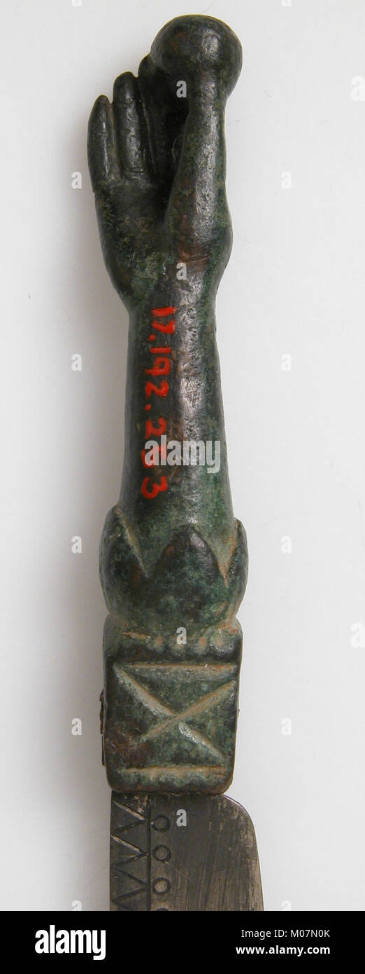 This ancient knife features a distinctive design with a hand holding an ...