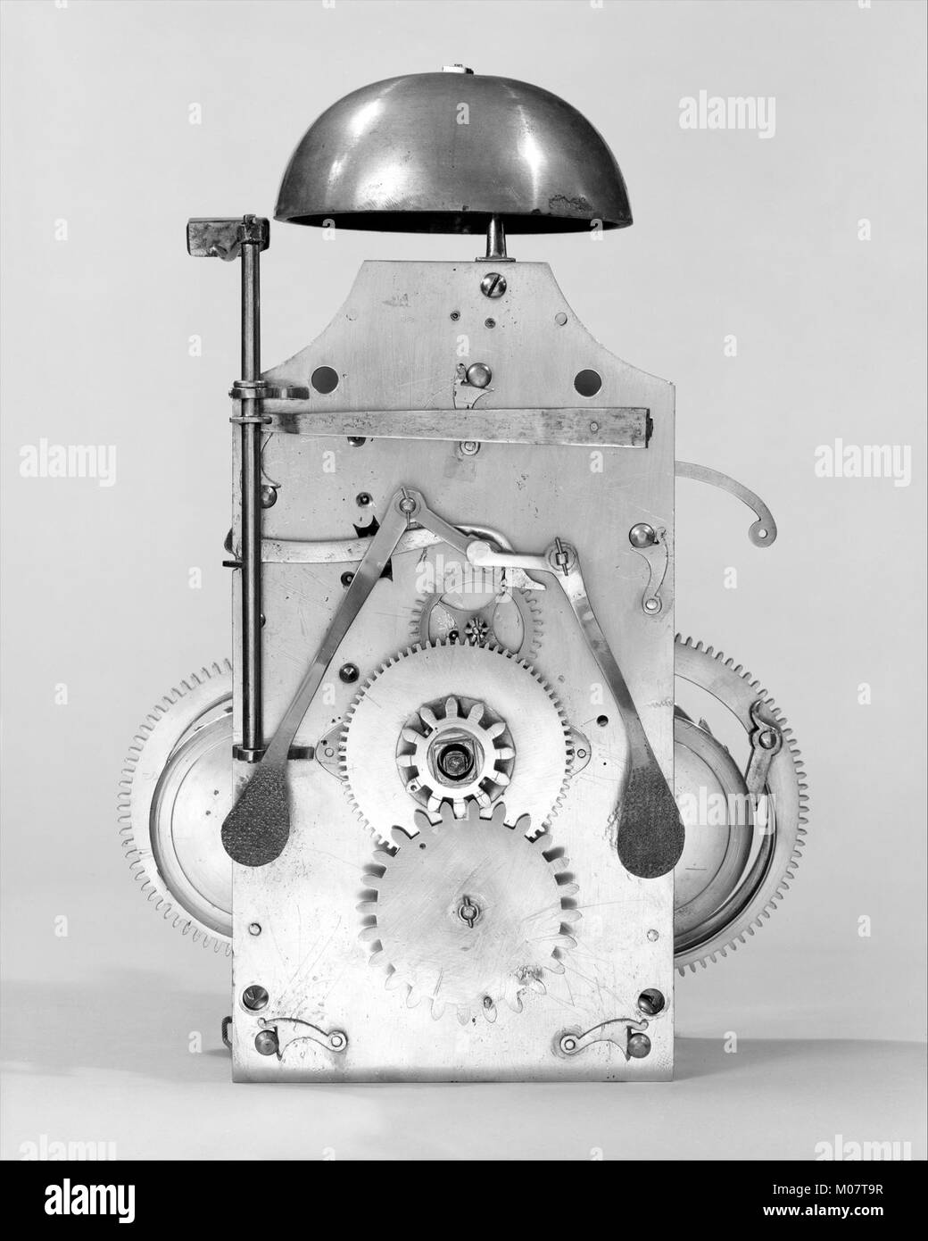 This hooded wall clock combines timekeeping and calendar functions ...